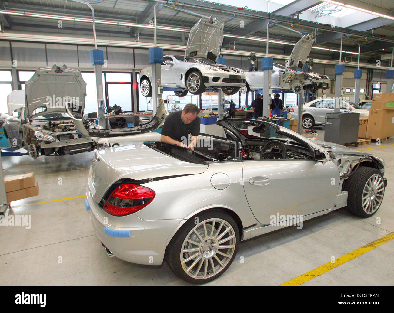 Two mechanics of AMG work on a car in the production site Affalterbach ...