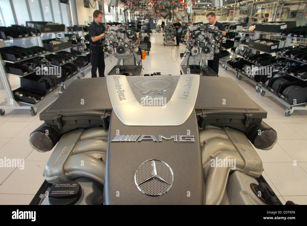 Two mechanics of AMG work on engines in the production site ...