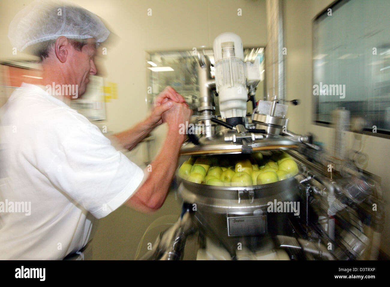 An employee of 'Nestle Deutschland AG' operates an apple crushing ...