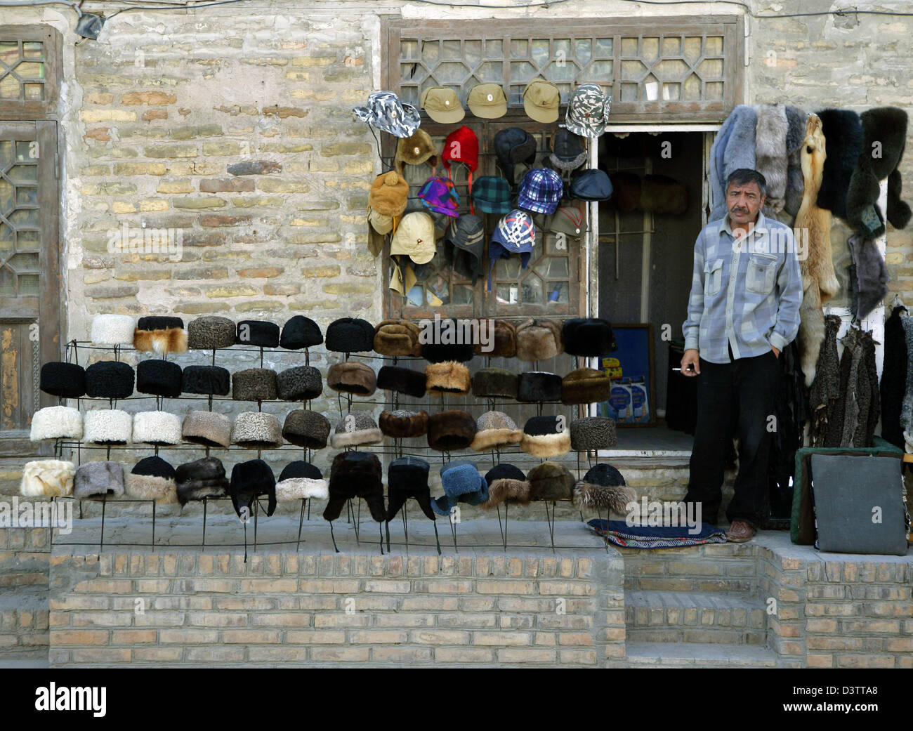 A cap-merchant poses in front of his shop in Bukhara, Uzbekistan ...