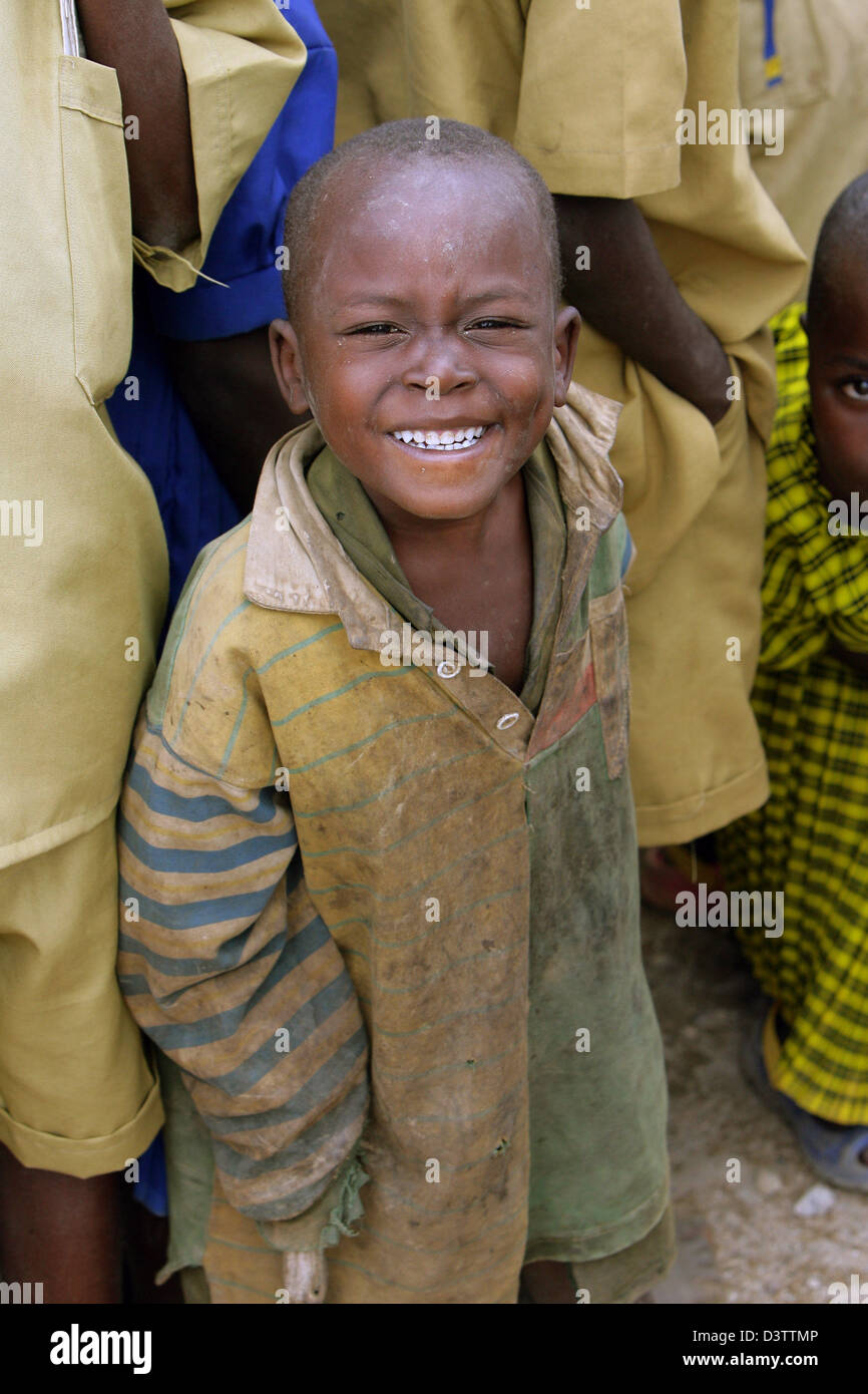 A Rwandan boy with dirty clothes smiles to the camera near Kigali ...