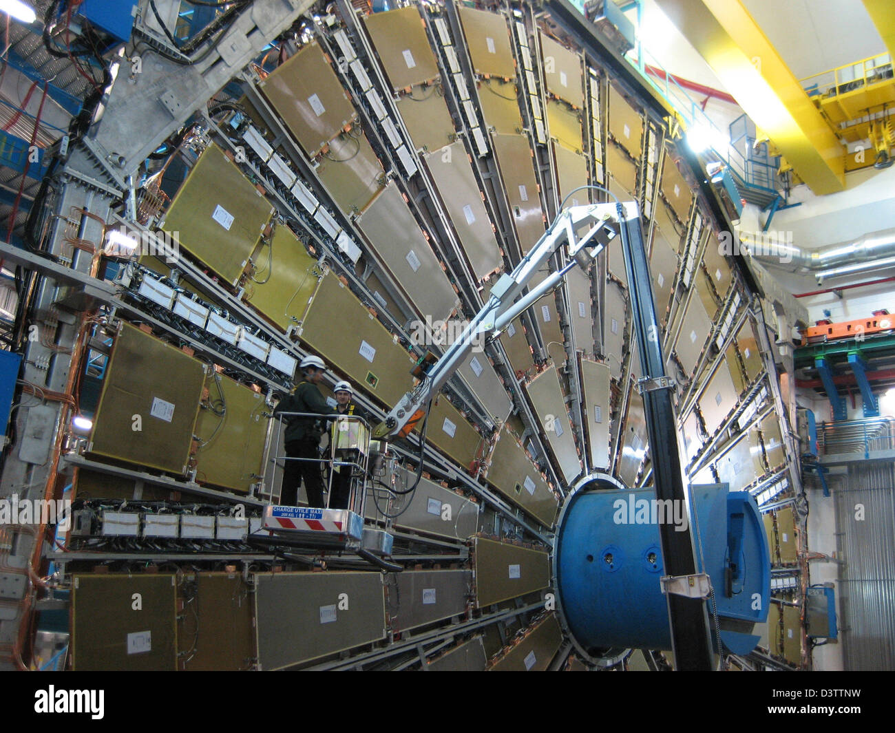 Two engineers work on a Compact Muon Solenoid (CMS)disc of the ATLAS (A ...