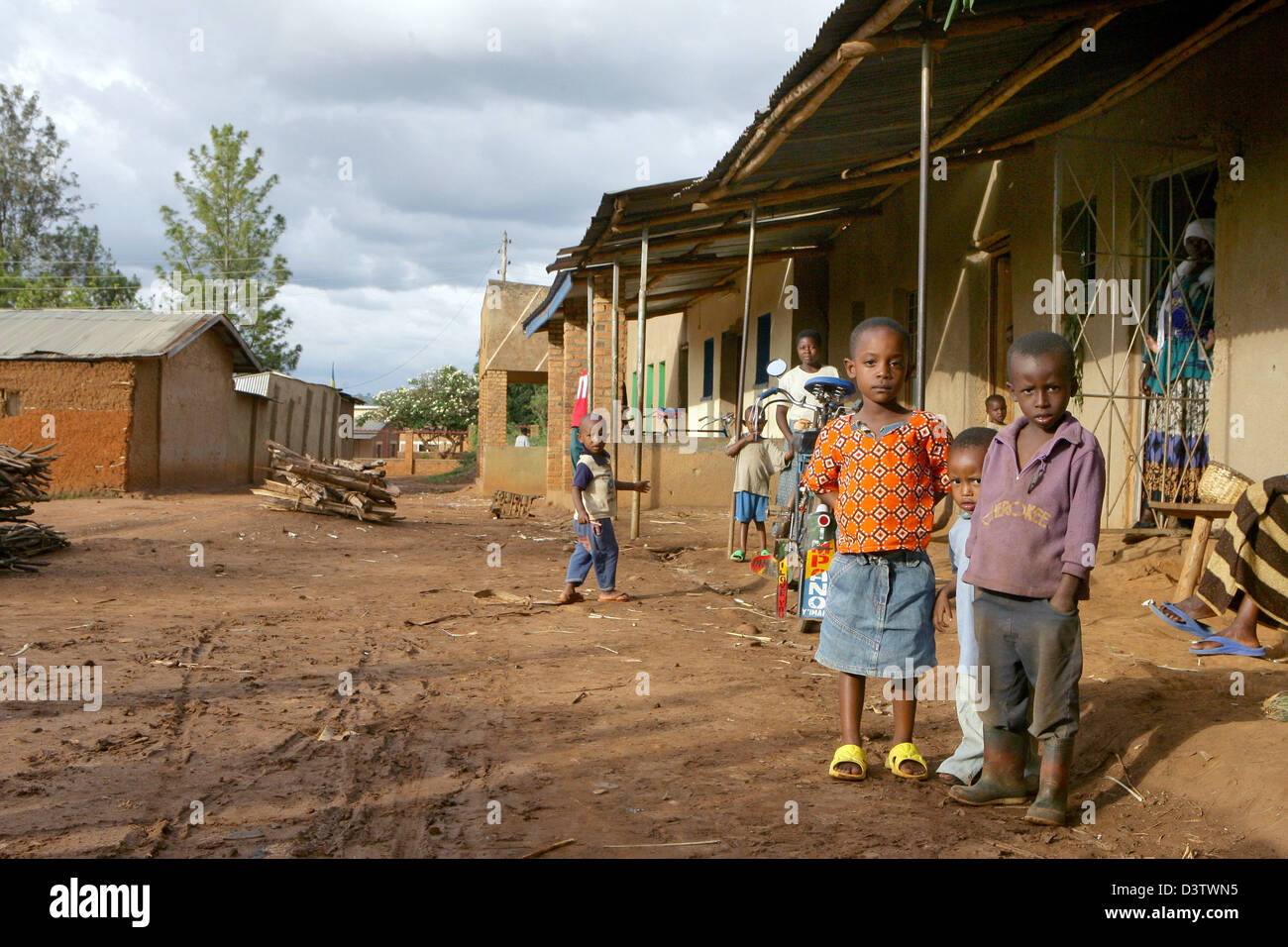The photo shows a street scene with children in a village near Kigali ...