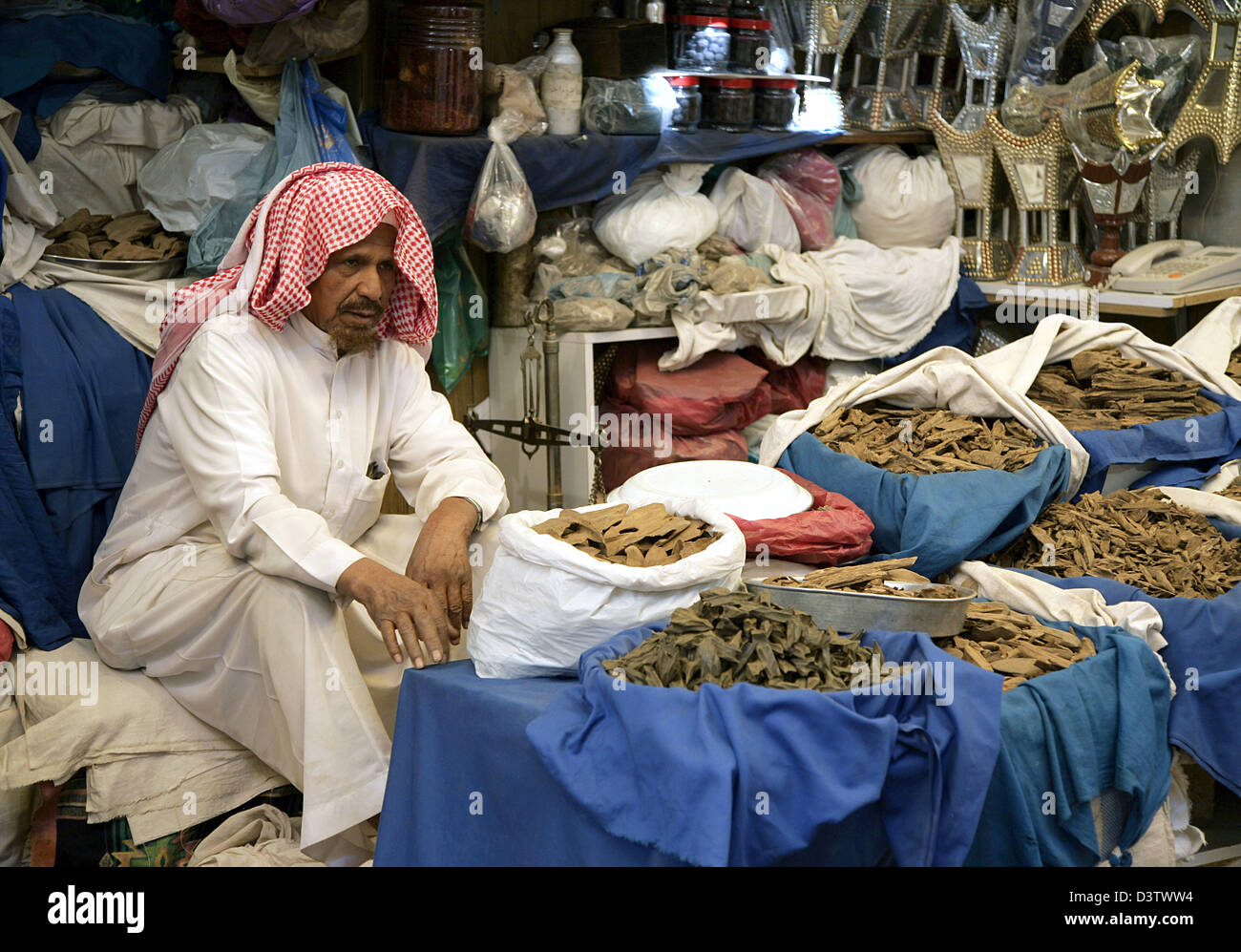 A merchant sits in between his fumigating goods and woods on the Souk ...