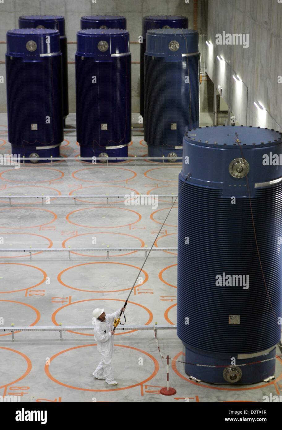 A worker measures a fuel rod container at the new nuclear interim ...
