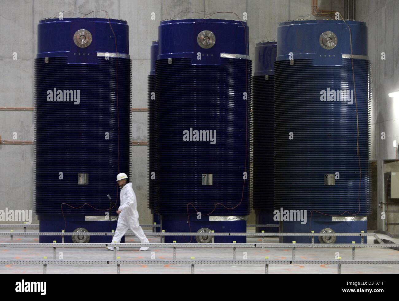 A worker measures a fuel rod container at the new nuclear interim ...