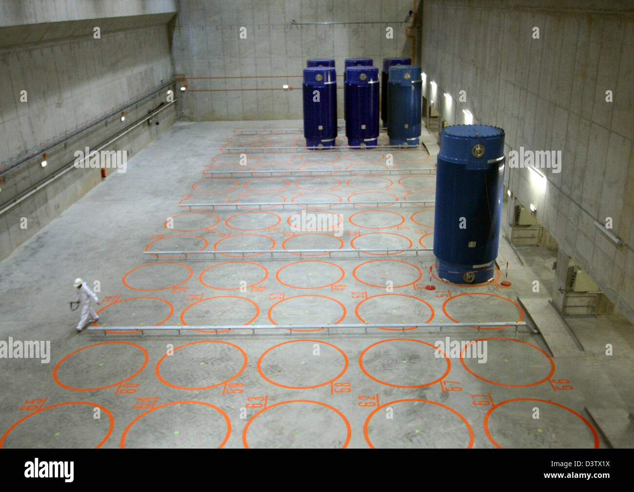 A worker measures a fuel rod container at the new nuclear interim ...