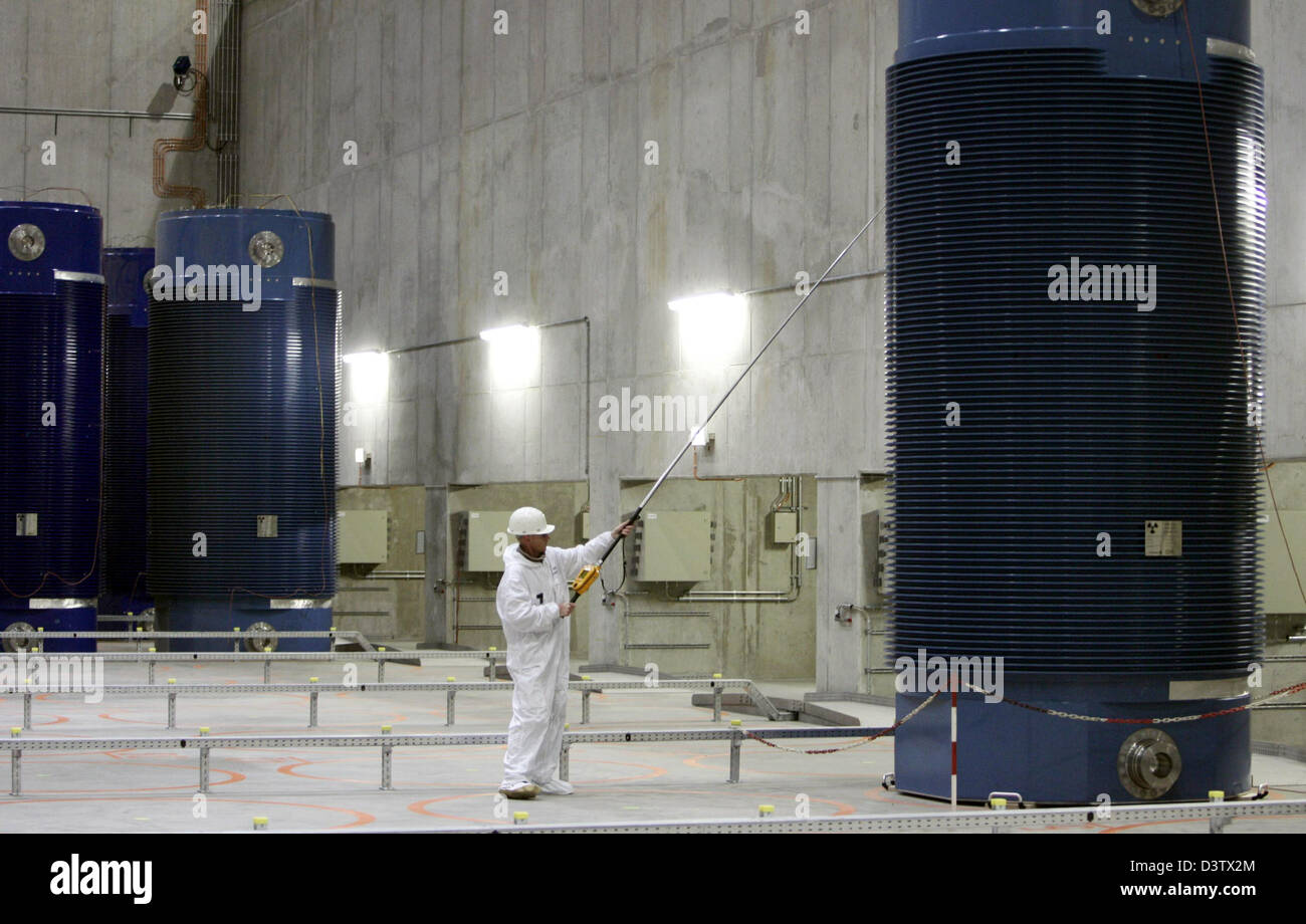 A worker measures a fuel rod container at the new nuclear interim ...