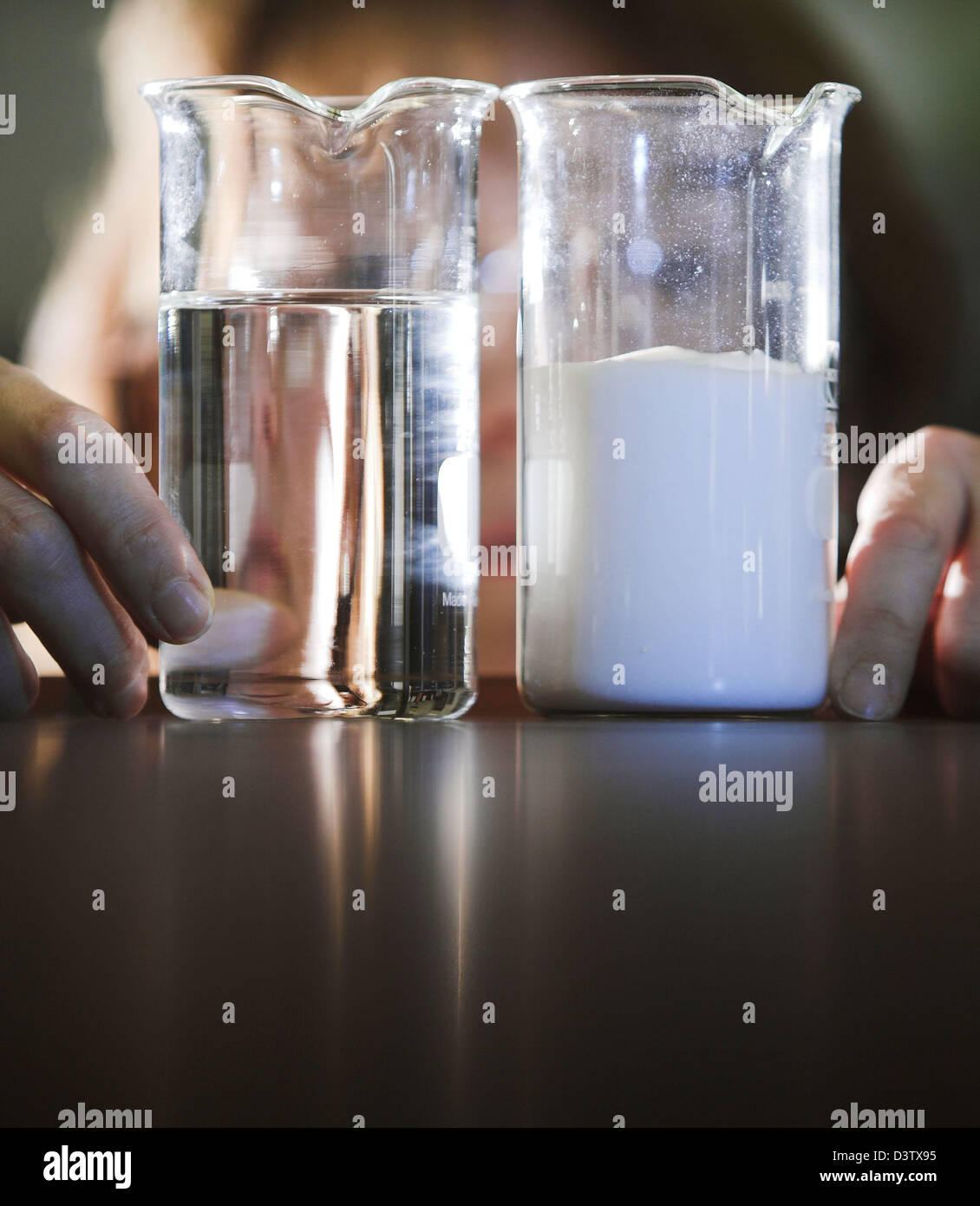 A chemist presents a cup of water (L) and a cup of Aerosil R 812 S ...