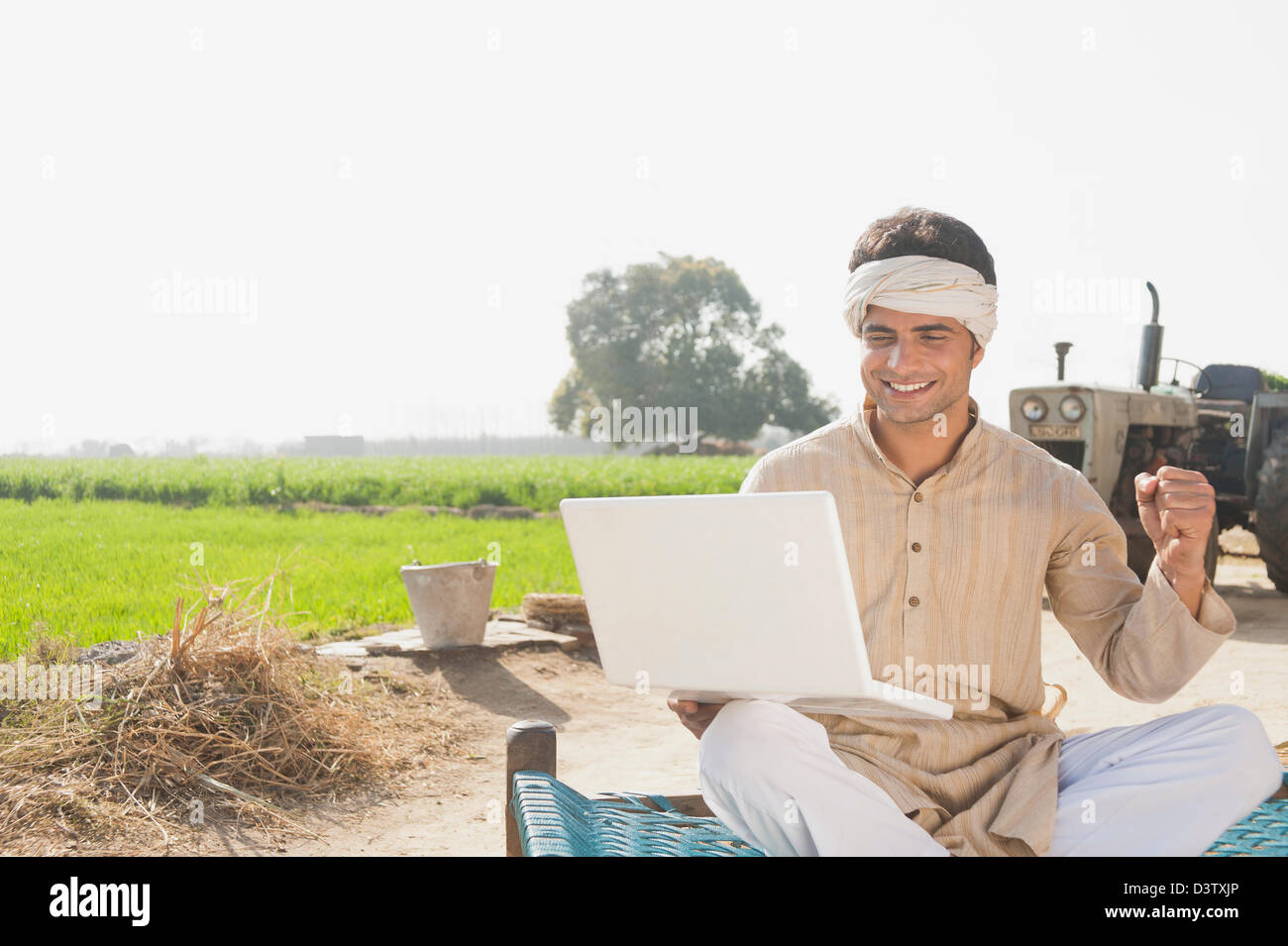 Farmer using a laptop in the field, Sonipat, Haryana, India Stock Photo ...