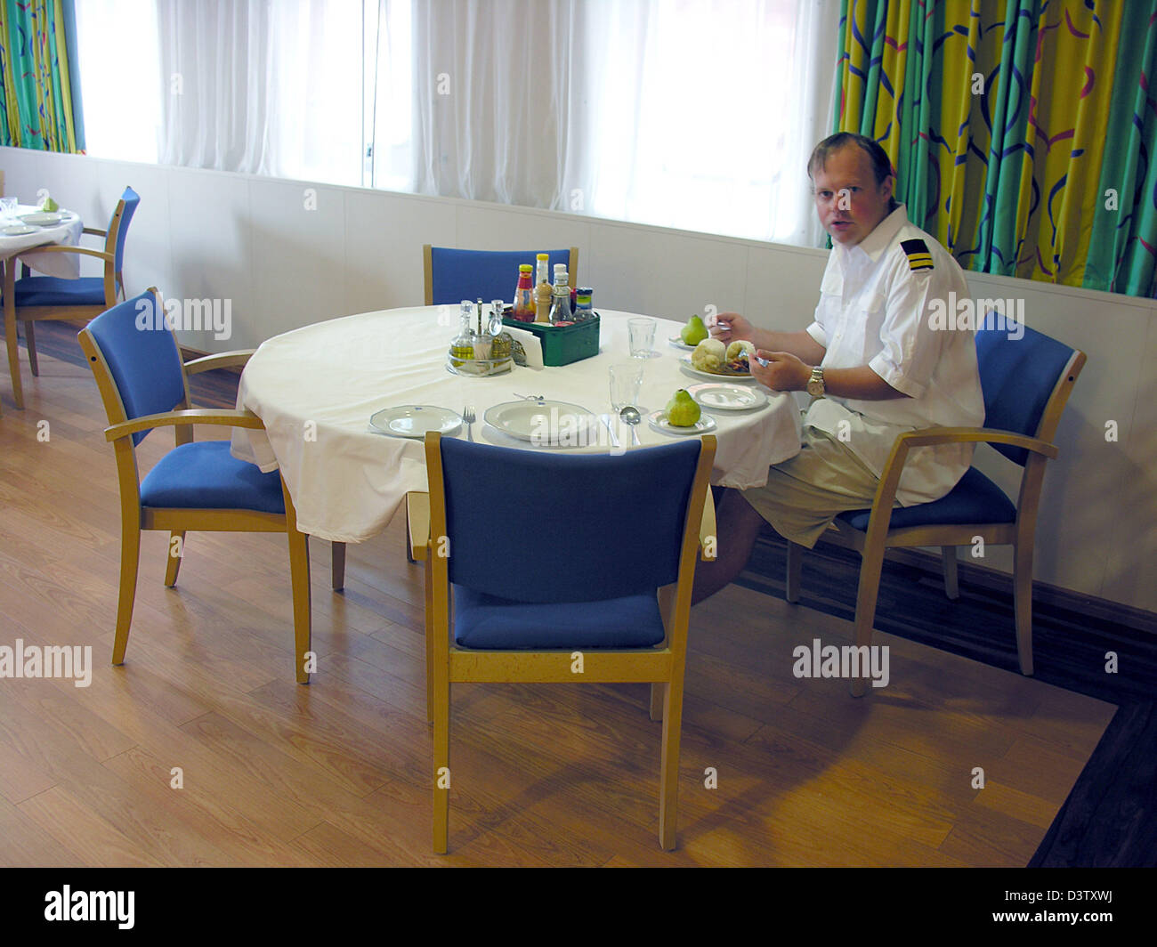 The captain sits at a table in the officers' mess of the container ship ...