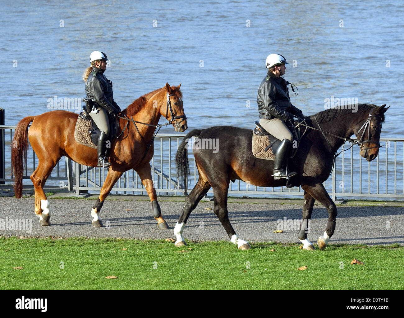 Two policemen of the riding squad pass along the Rhine in Duesseldorf ...