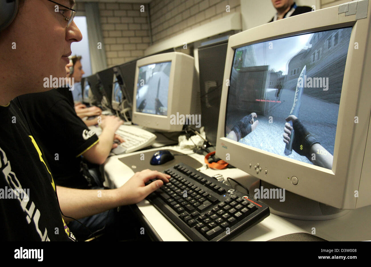 Young people sit in front of computer screens and play the game ...