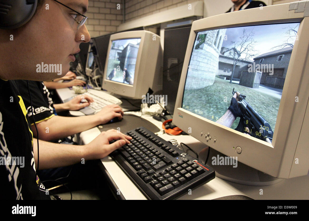 Young people sit in front of computer screens and play the game ...