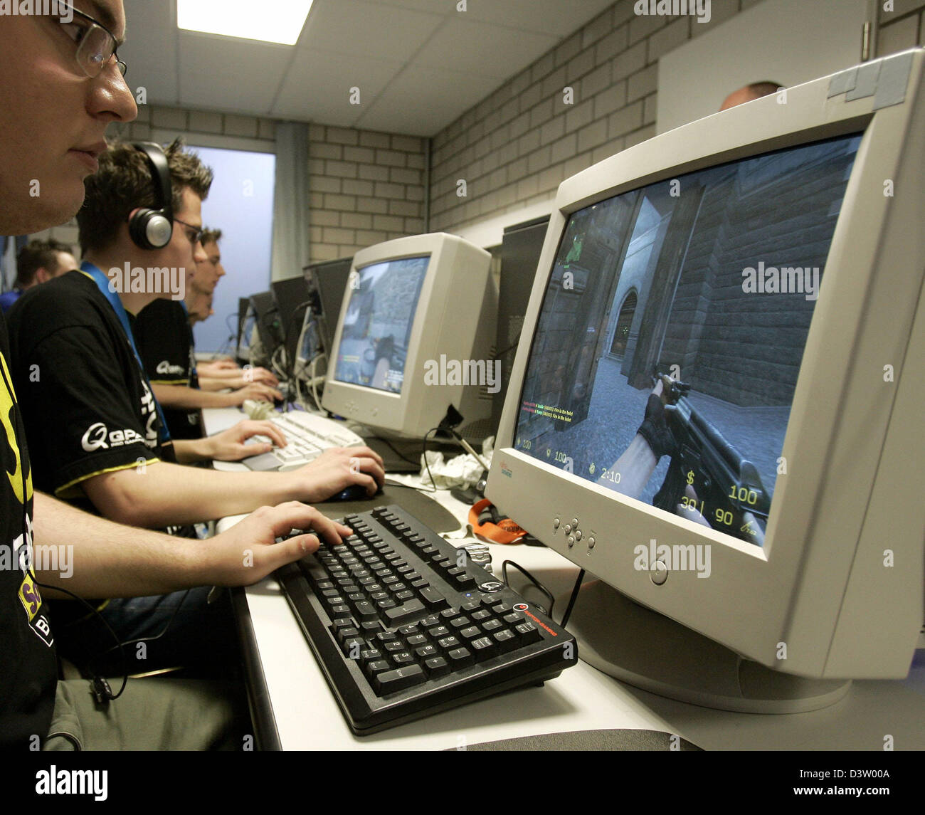 Young people sit in front of computer screens and play the game ...