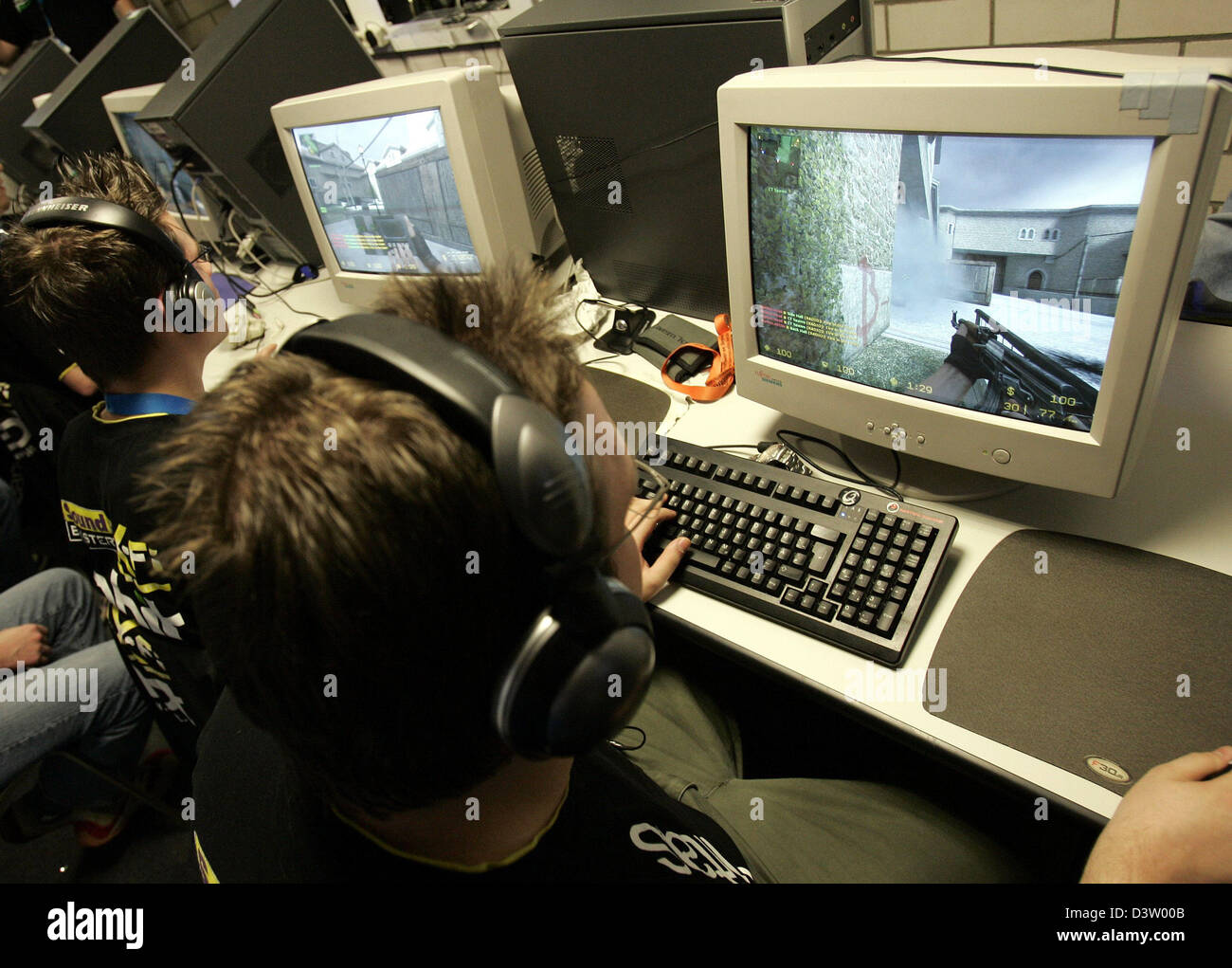 Young people sit in front of computer screens and play the game ...