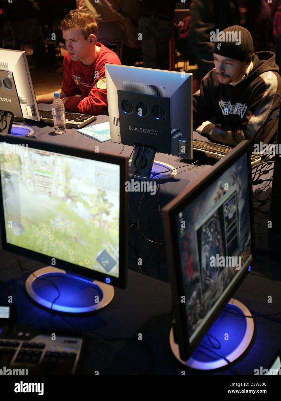Young people sit in front of computer screens and play the game ...