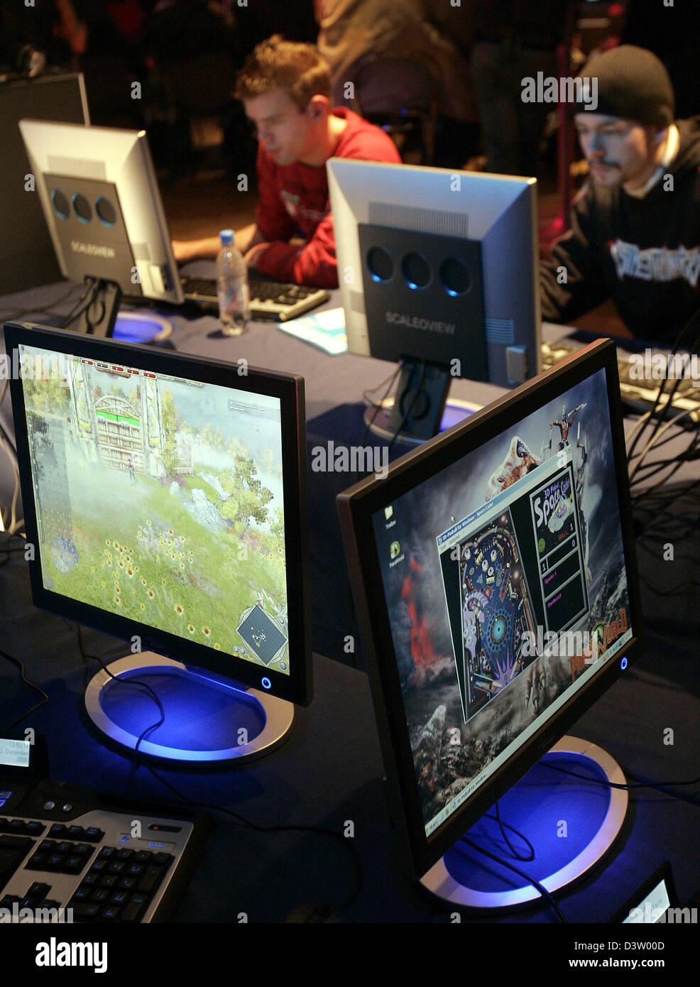 Young people sit in front of computer screens and play the game ...