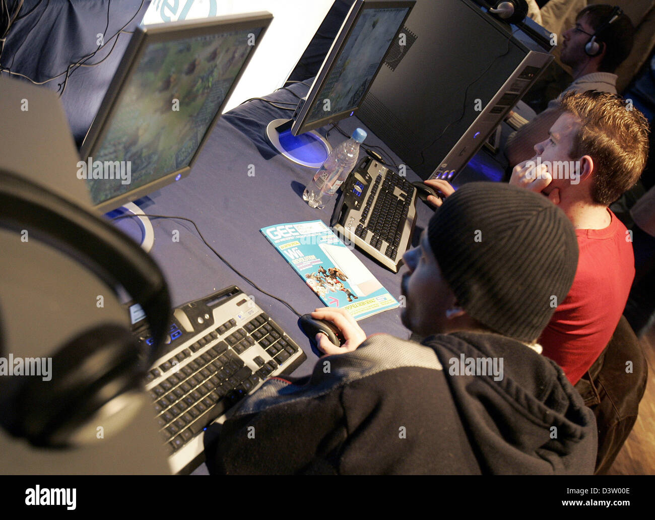 Young people sit in front of computer screens and play the game ...