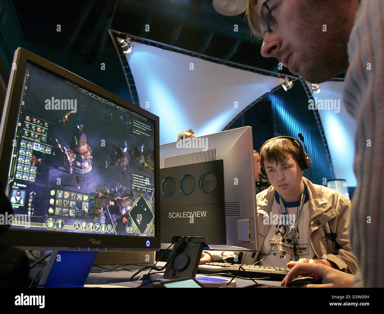 Young people sit in front of computer screens and play the game ...