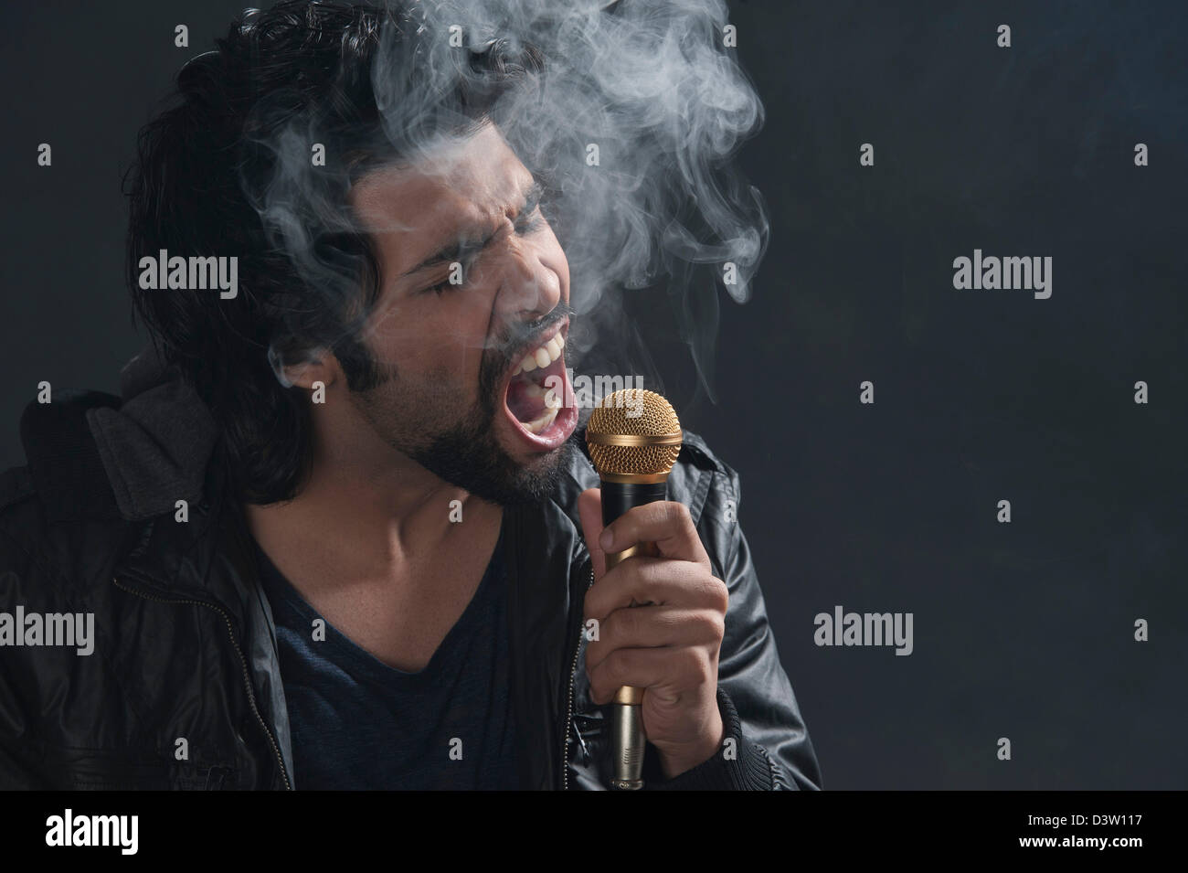 Singer holding a mike and singing Stock Photo - Alamy