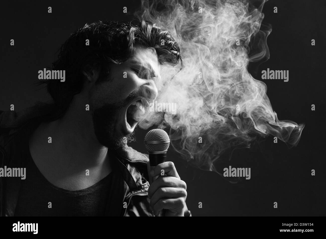 Singer holding a mike and singing Stock Photo - Alamy