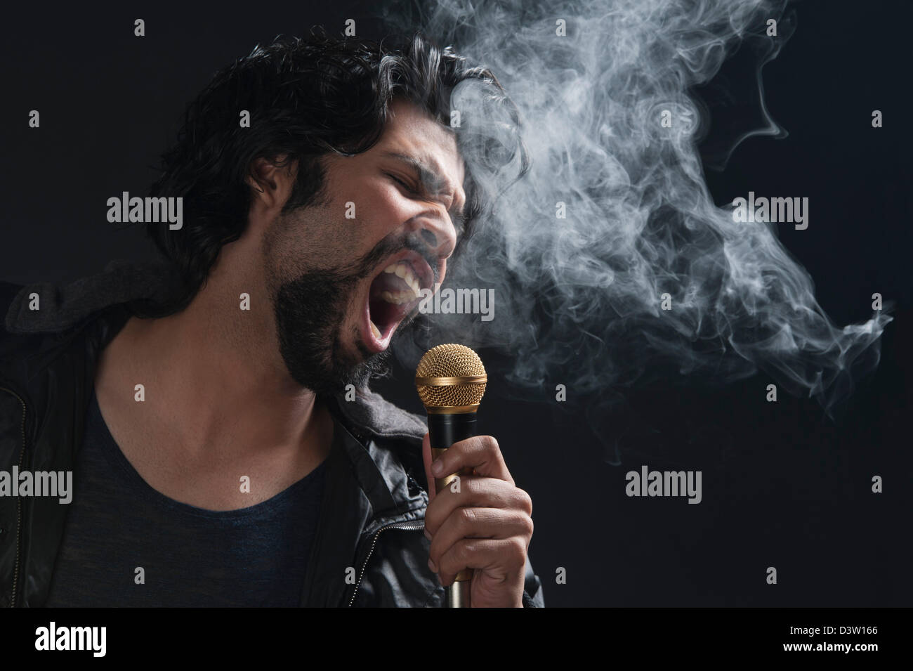 Singer holding a mike and singing Stock Photo - Alamy