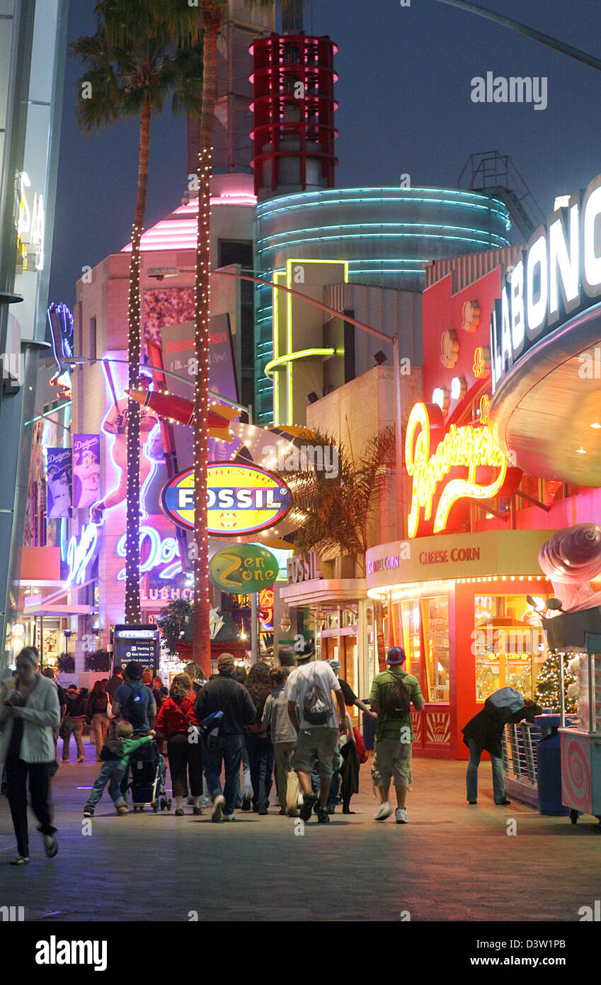The picture shows visitors on a street illuimated by many neon signs at ...