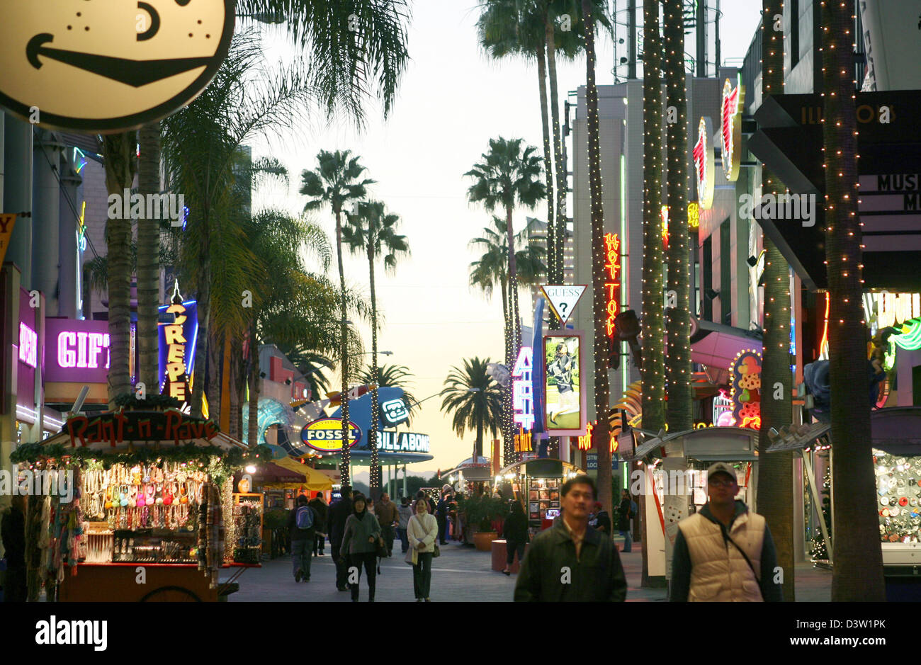 The picture shows visitors on a street illuminated by many neon signs ...