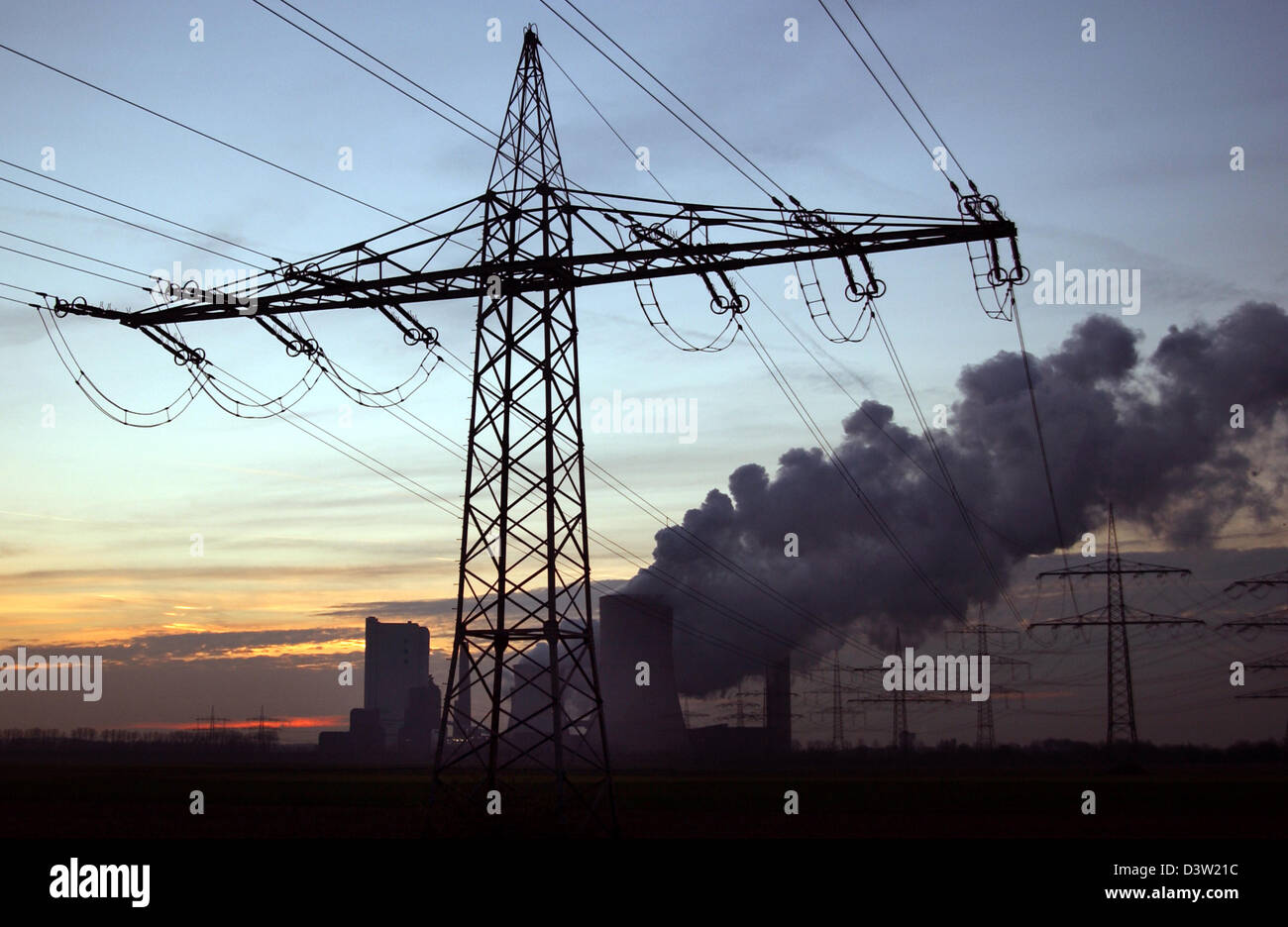 Vapour rises from cooling towers in front of the setting sun and behind ...