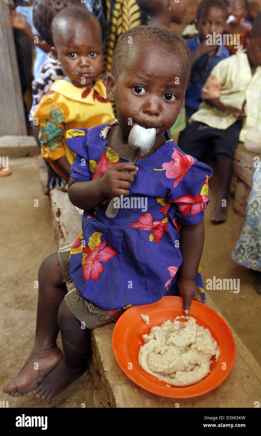 (dpa file) - School children sit on wooden benches while they eat corn ...