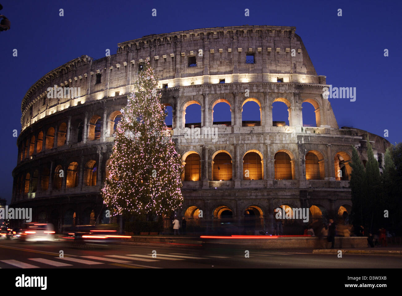 The photo shows a christmas tree decorated with lights in front of the ...