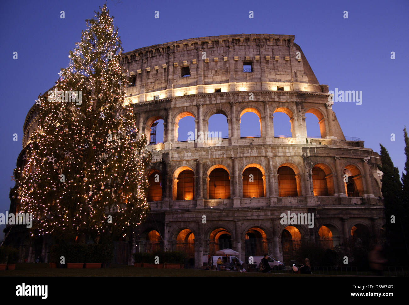 The photo shows a christmas tree decorated with lights in front of the ...