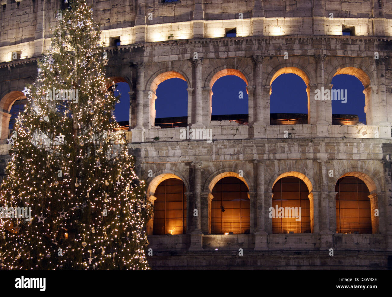 The photo shows a christmas tree decorated with lights in front of the ...