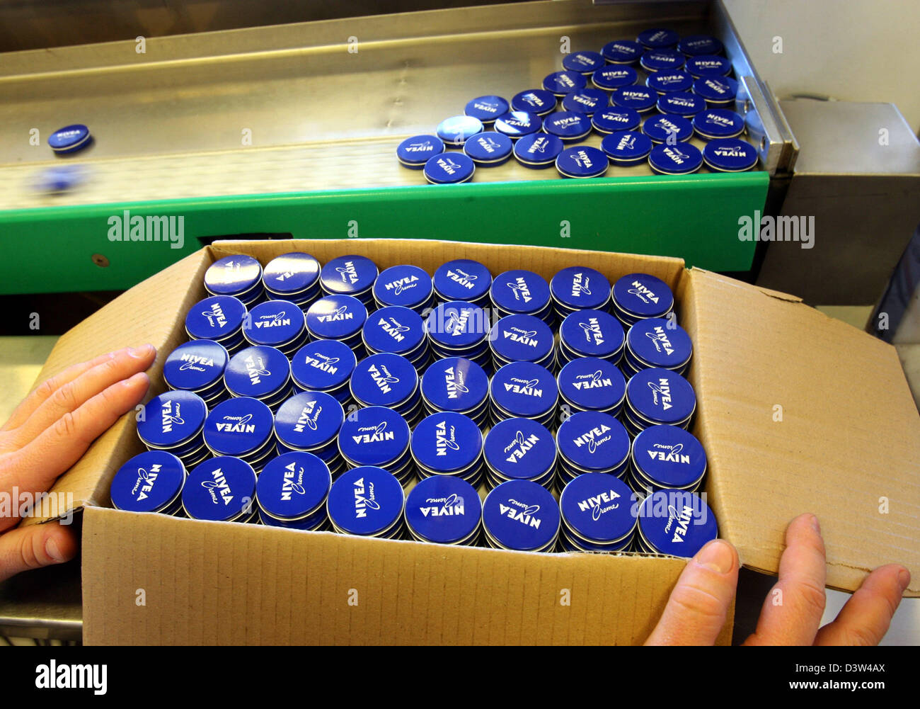 The well-known blue Nivea tins are packaged in a production plant of ...