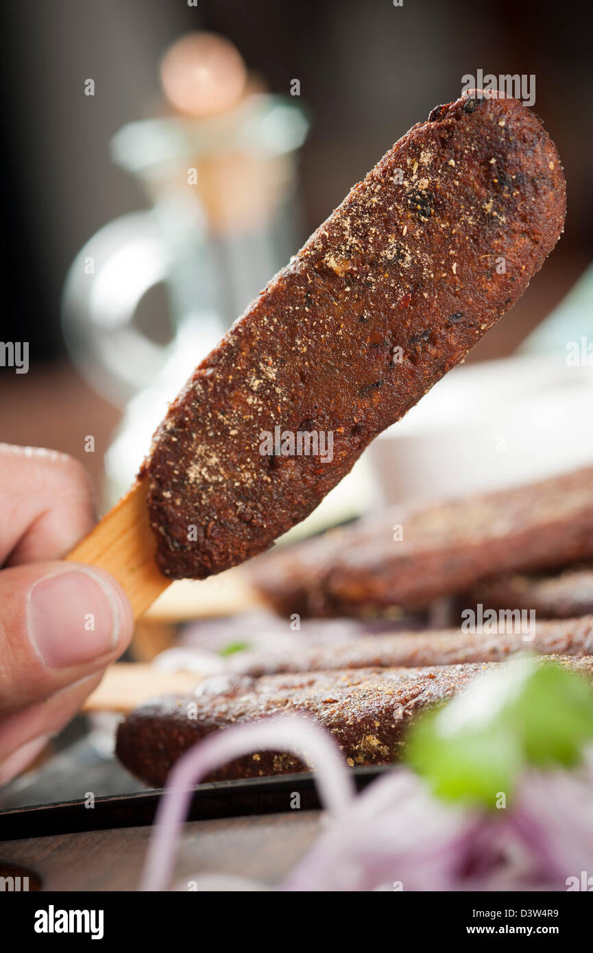 Close-up of a person's hand holding kebab Stock Photo - Alamy