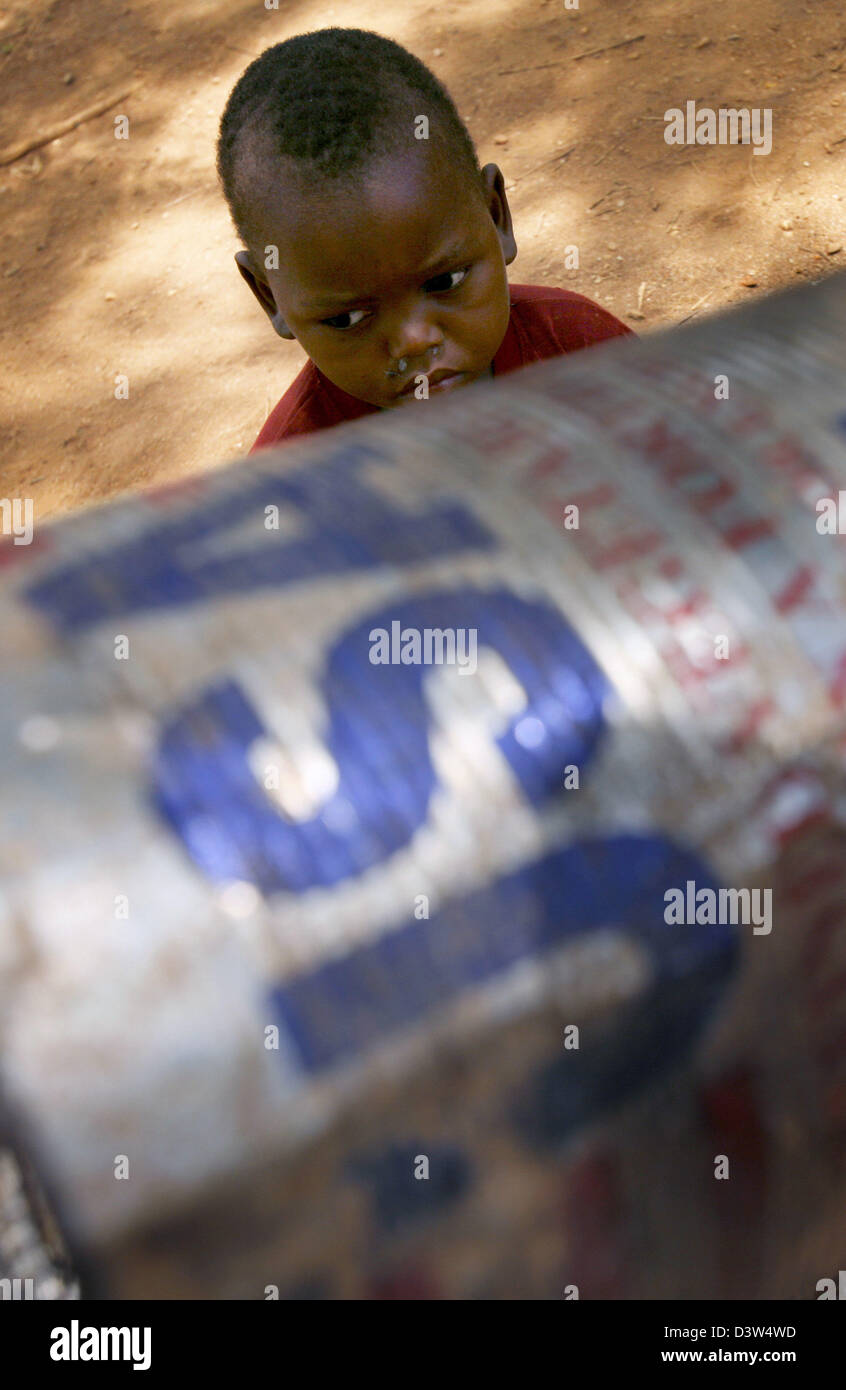 A boy pictured behind his self-made music instrument composed of a tin ...