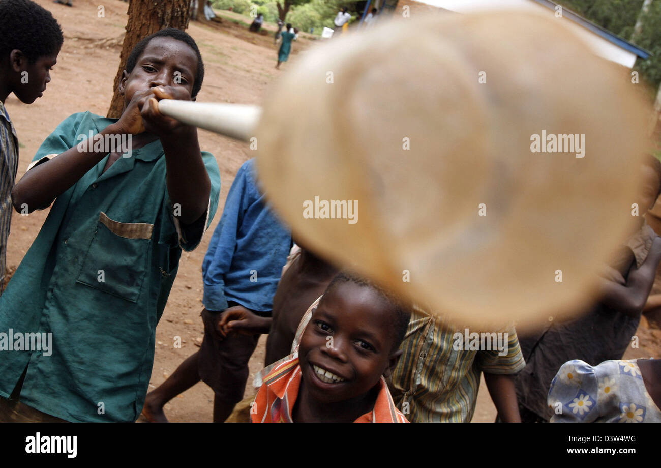 A young man plays his self-made wind instrument in the village of ...