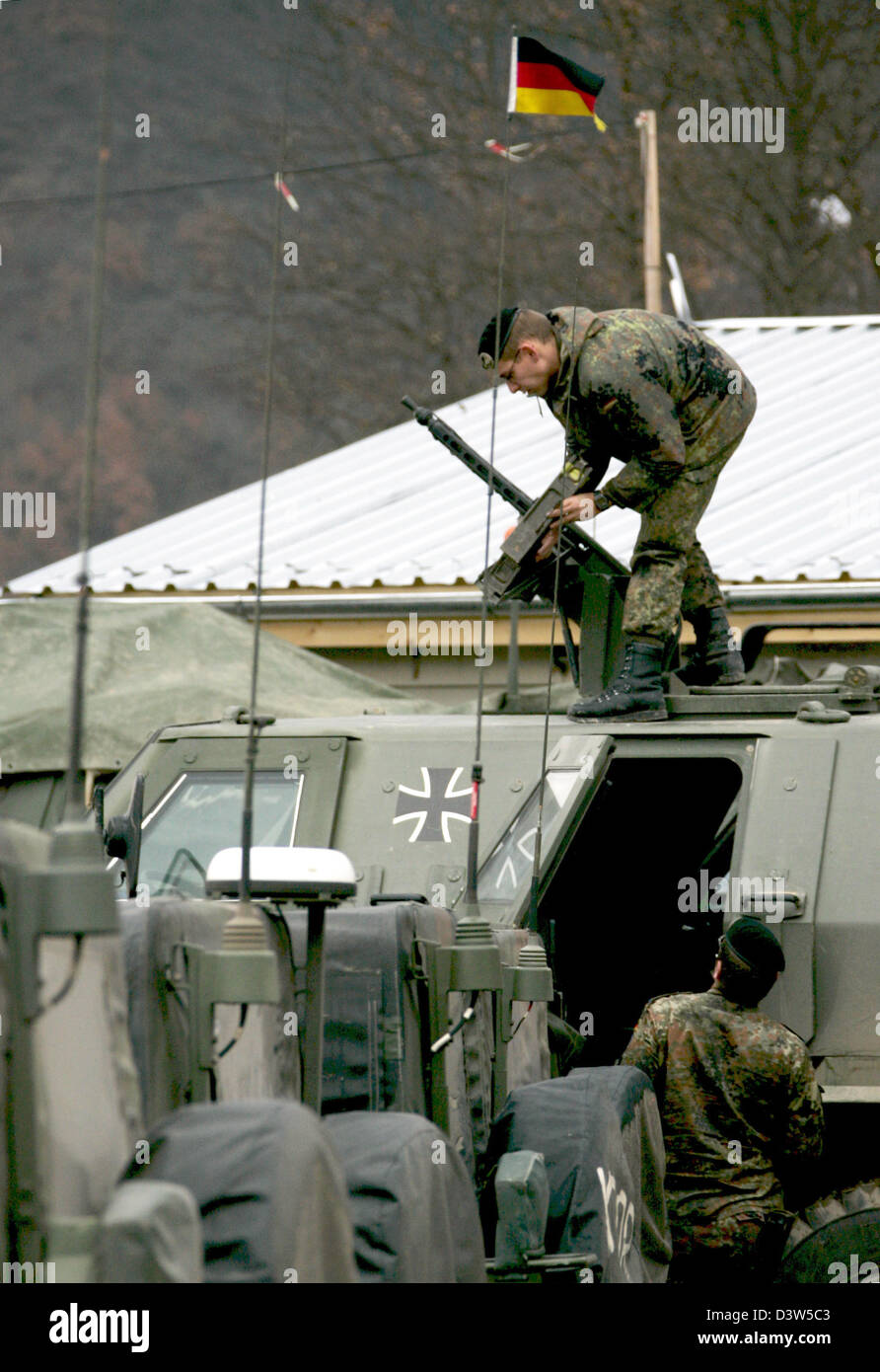 Two Bundeswehr soldiers assemble a machine gun on an armoured car in ...