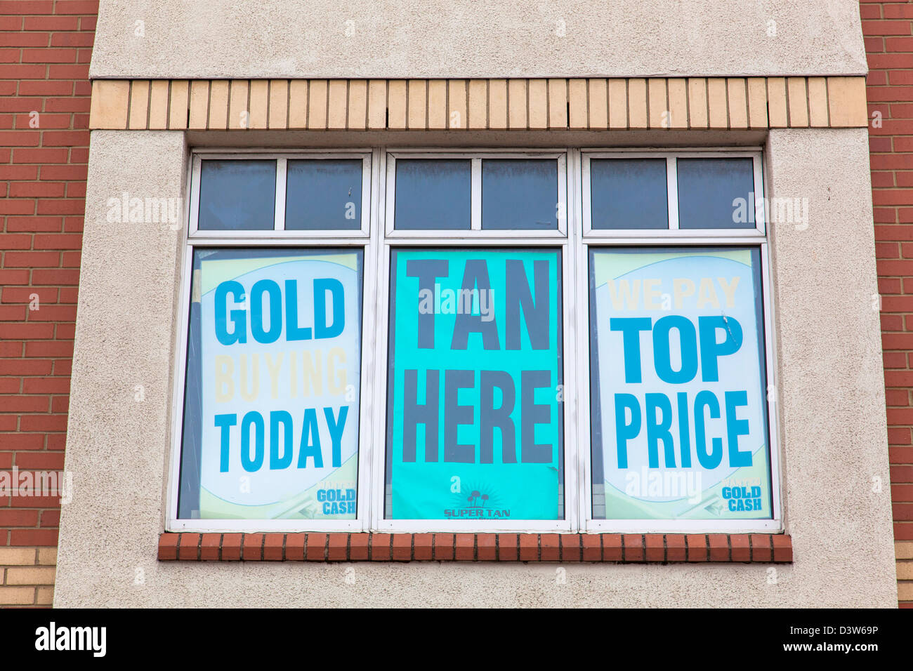 Signs in a window for tanning and buying gold Stock Photo - Alamy