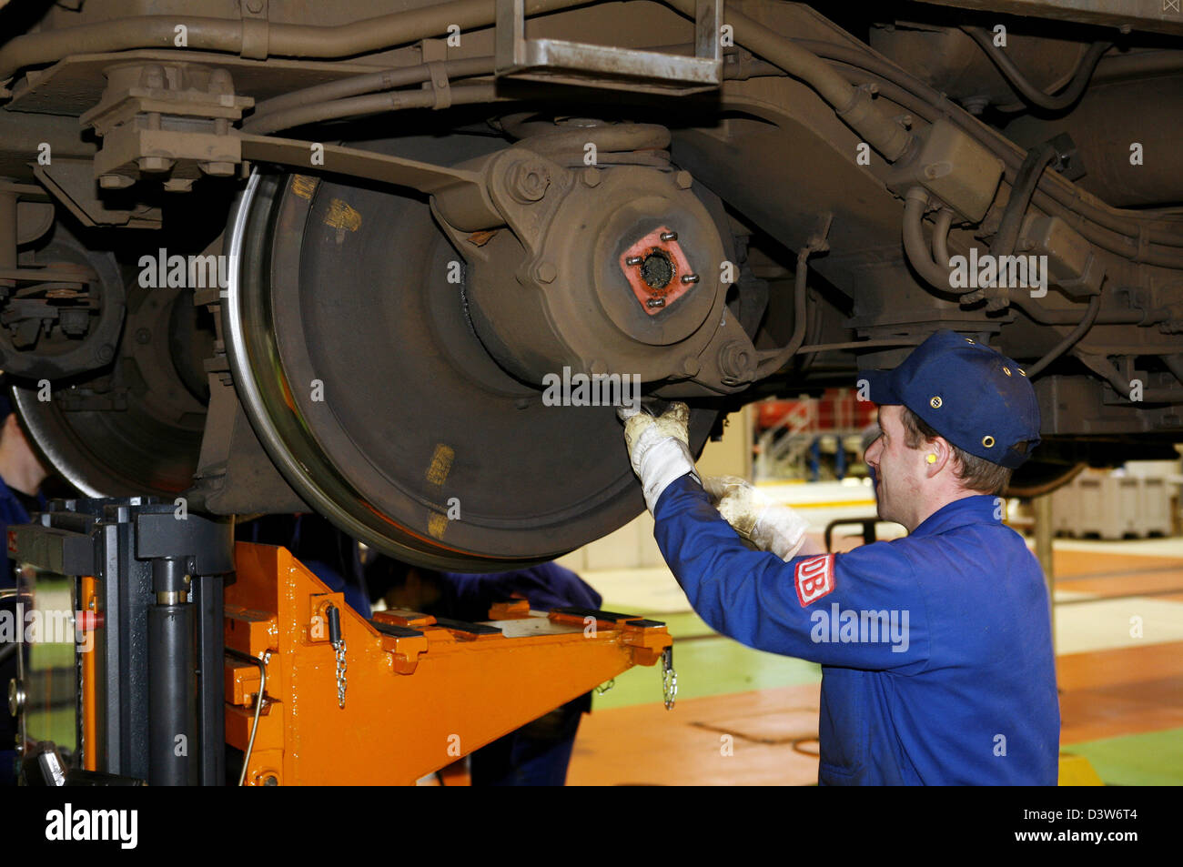 Mechanics change an axle of a 'S-Bahn' regional train at a railway ...