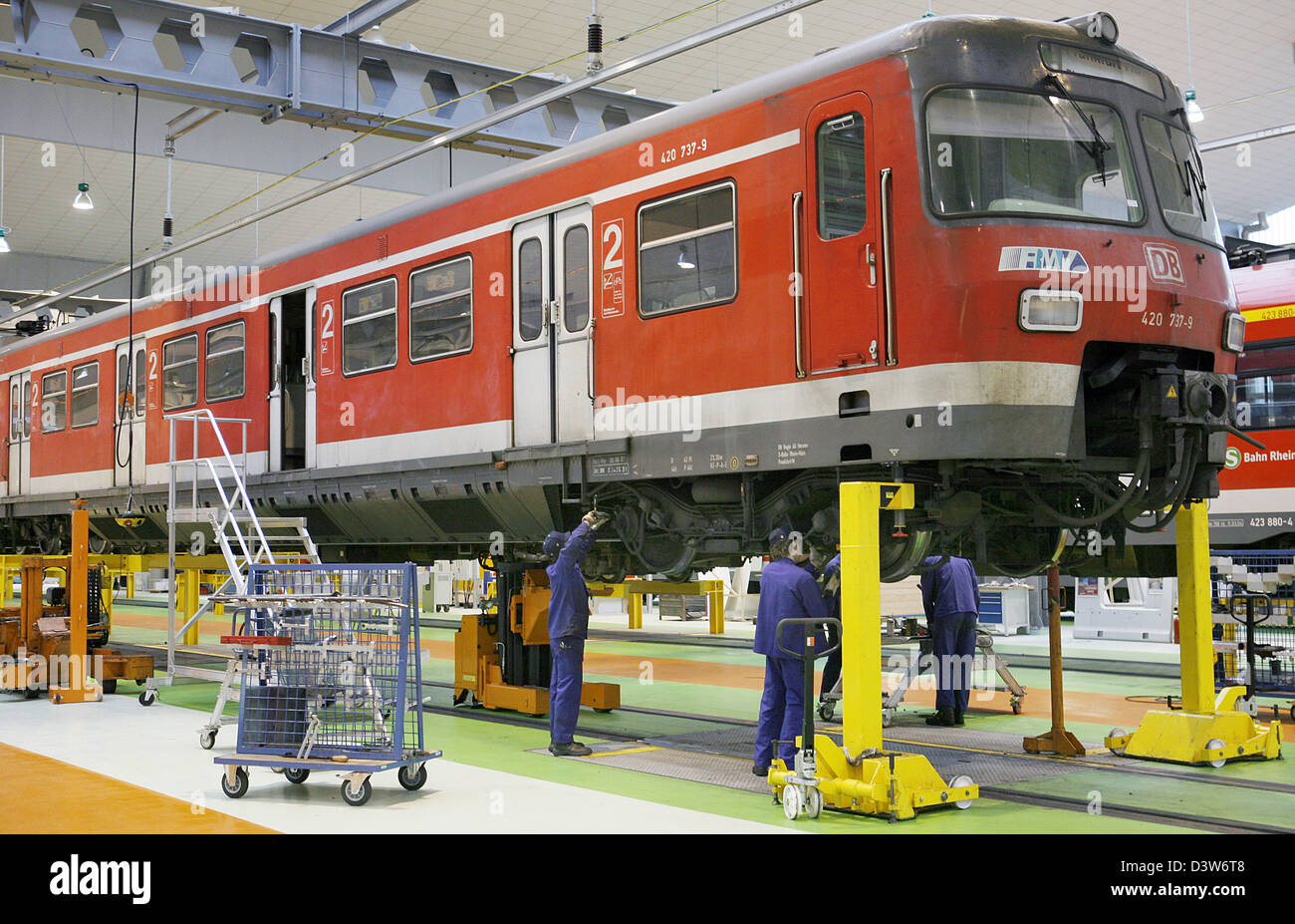 Mechanics change an axle of a S-Bahn regional train at a railway ...