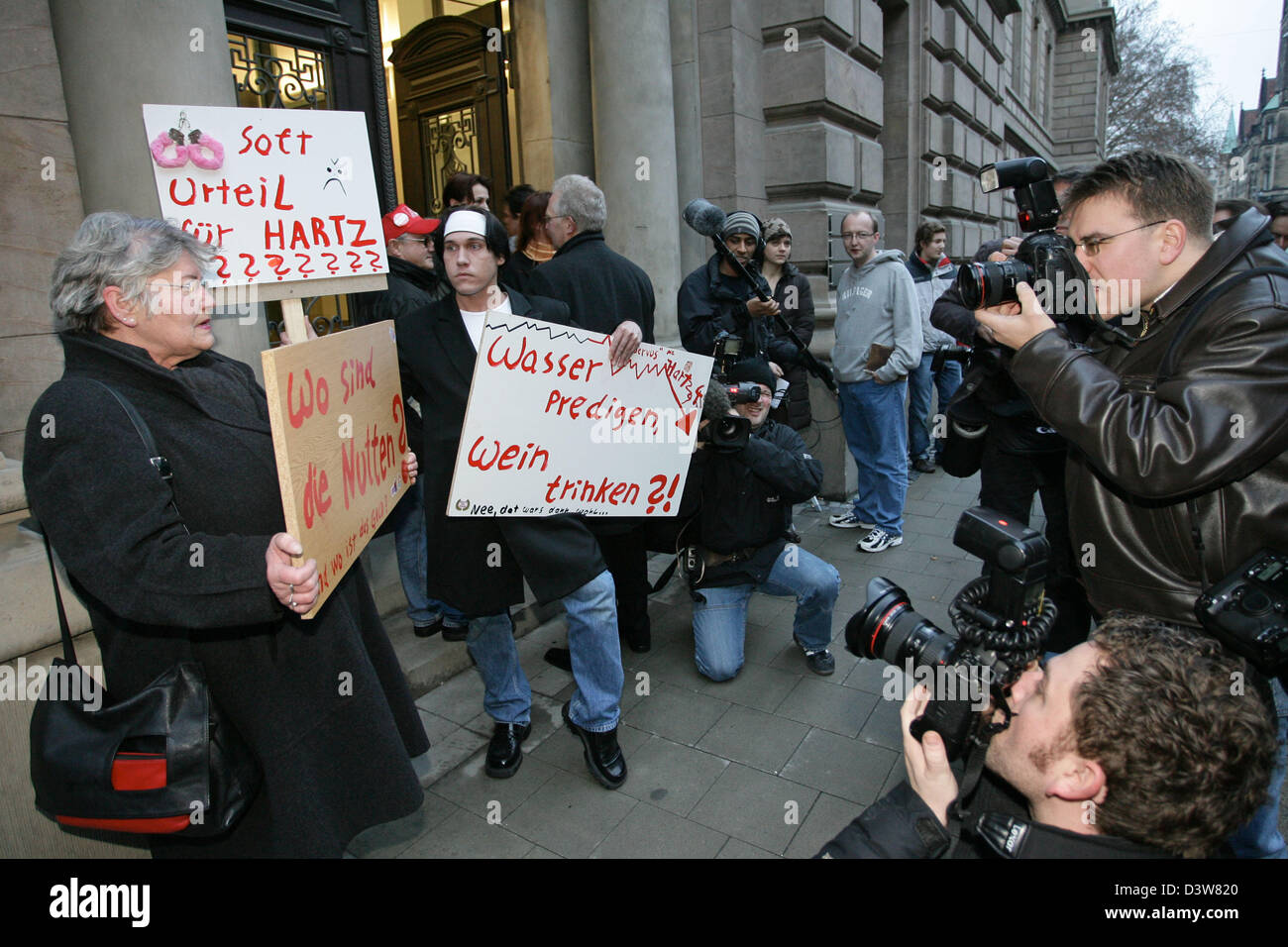 Demonstrators with protest signs surrounded by photographers stand in ...