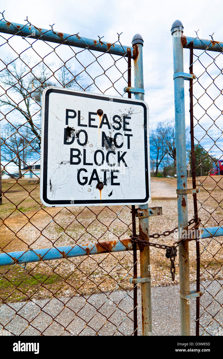 Please do not block gate sign on rusty blue fence with blue sky and ...