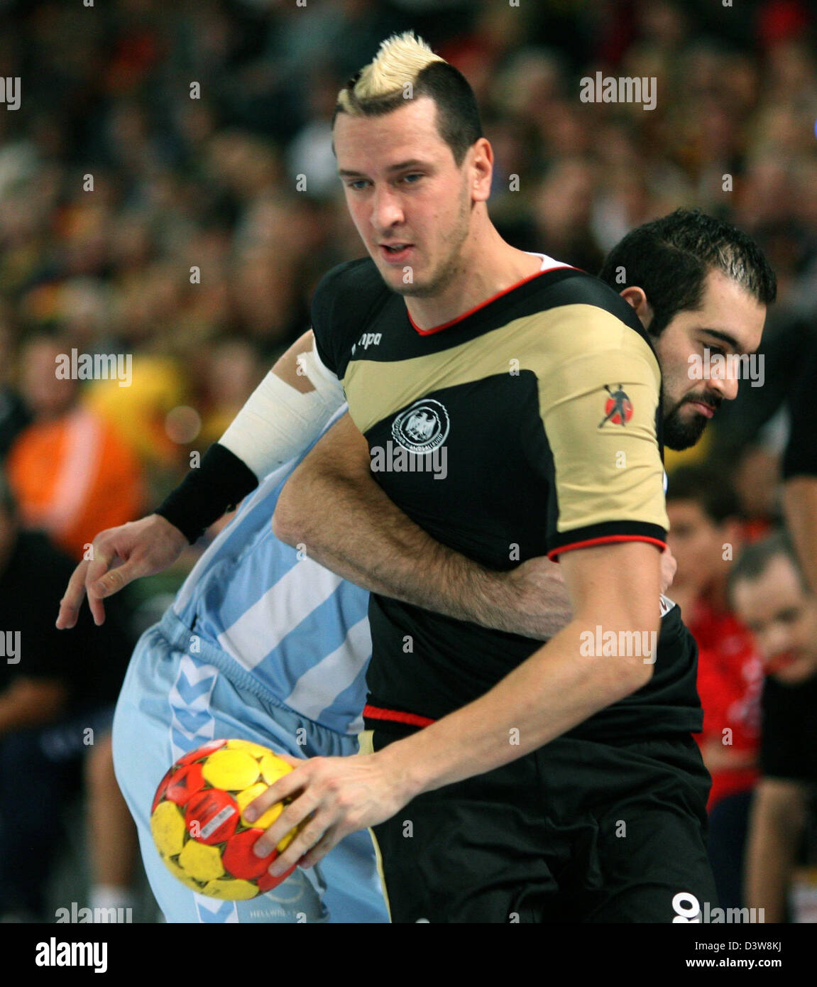 German handball national team player Pascal Hens (R) is attacked by ...