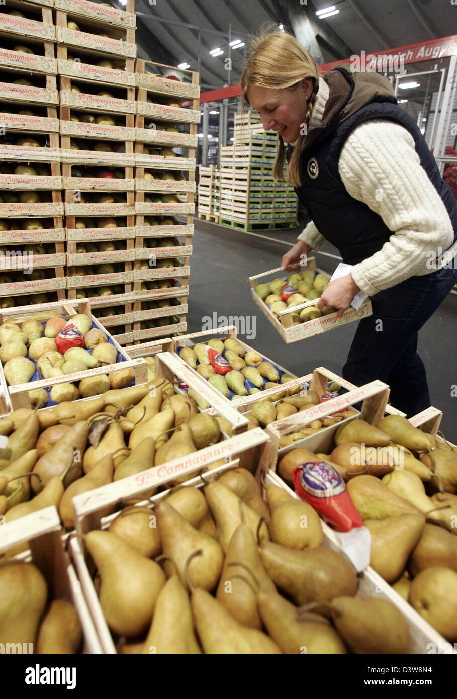 A worker stacks crates of pears at the wholesale market in Hamburg ...