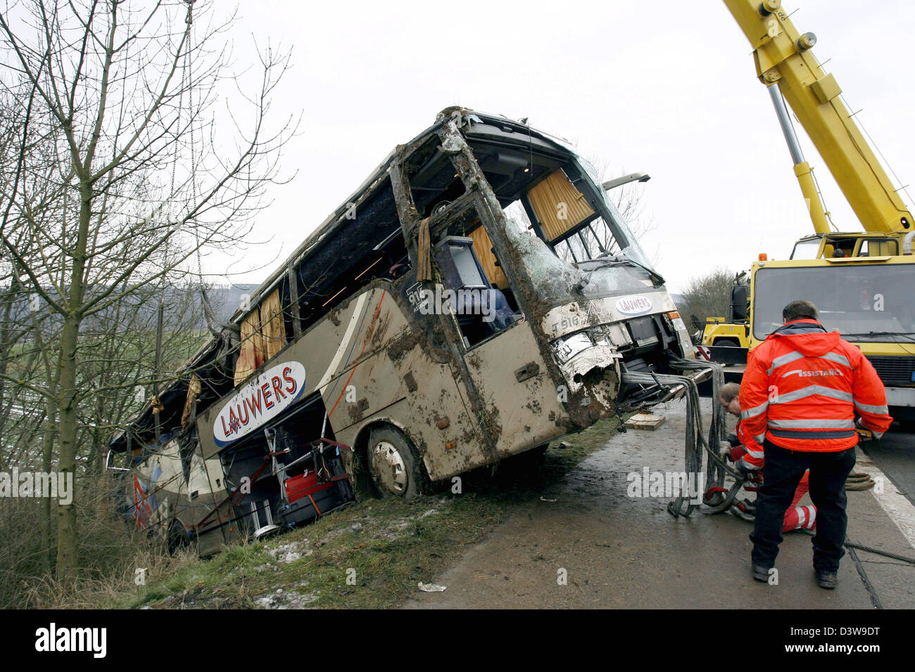Employees of a wrecking service recover a wrecked coach after an ...