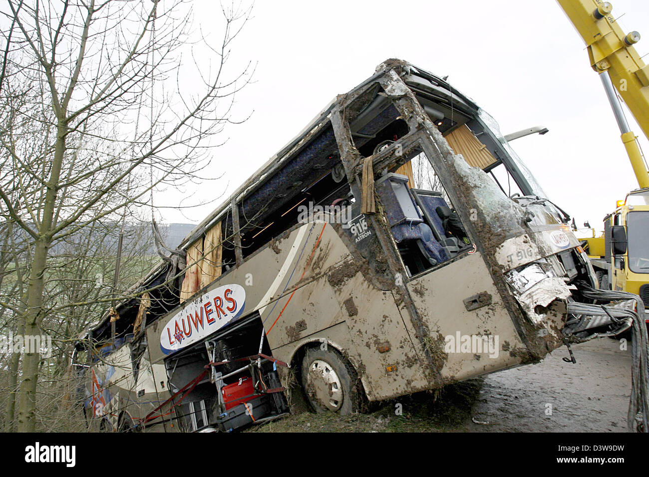 Employees of a wrecking service recover a wrecked coach after an ...