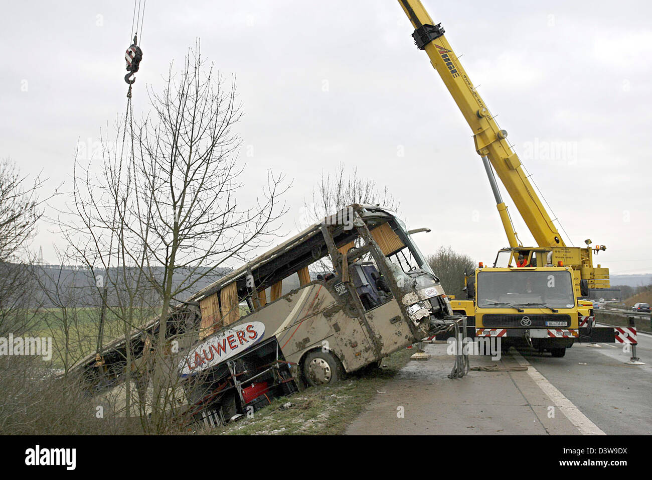Employees of a wrecking service recover a wrecked coach after an ...