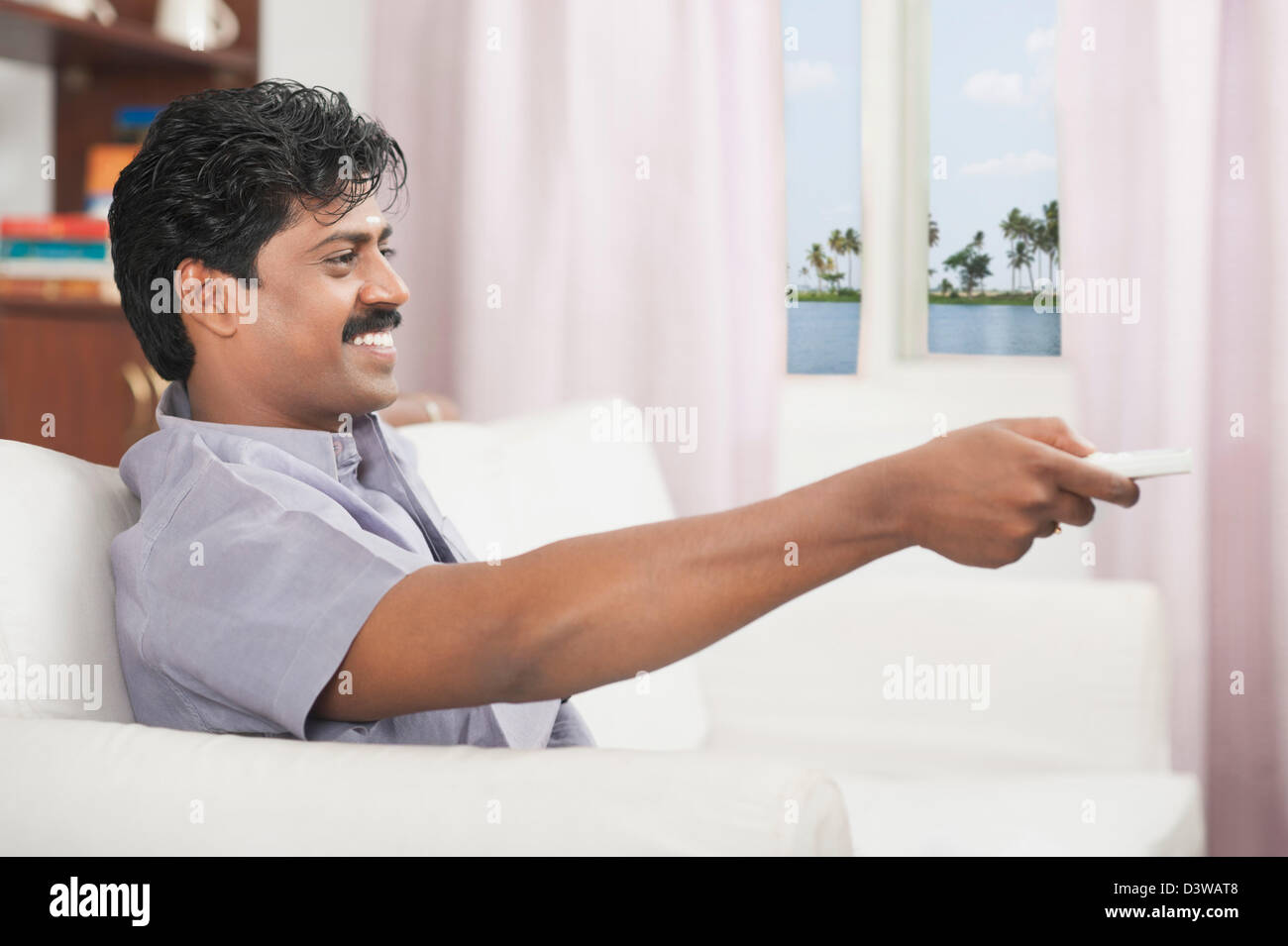 South Indian man watching TV Stock Photo - Alamy
